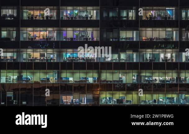 Modern office building with big windows at night timelapse, in windows ...