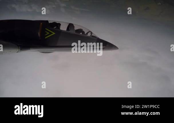 Gray combat fighter plane make Split S maneuver against a cloudy sky ...