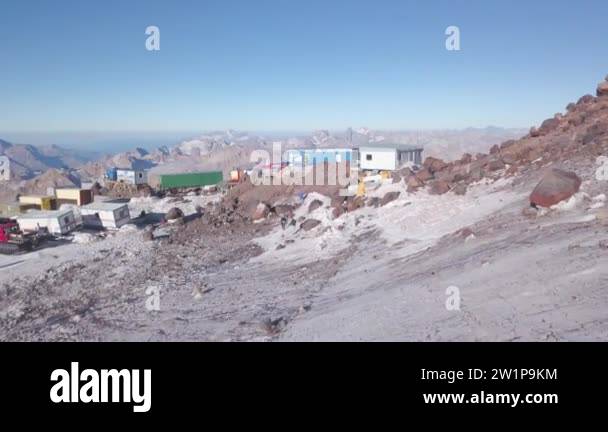 Snowmobiles and houses in snowy mountains. Clip. Top view of snowcats ...