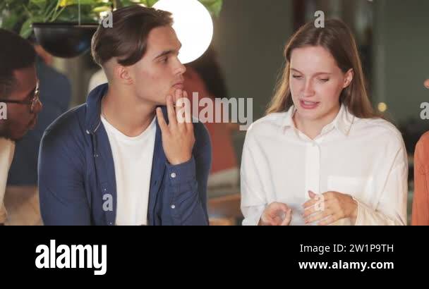 Young pretty woman talking while sharing her idea with colleagues in ...