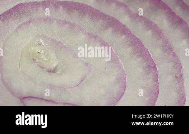 Sliced red onion rings rotating in 4K. Closeup top view of healthy food ...