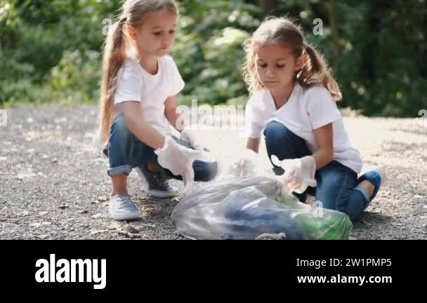 Two little girls collecting garbage together in forest Stock Video ...