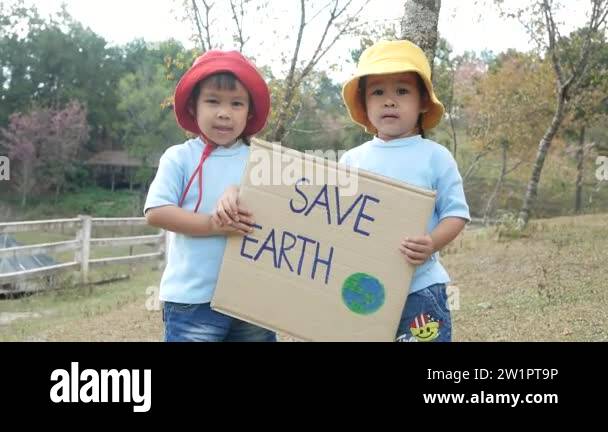 Two little child girl siblings holding "Save the planet" Poster showing ...