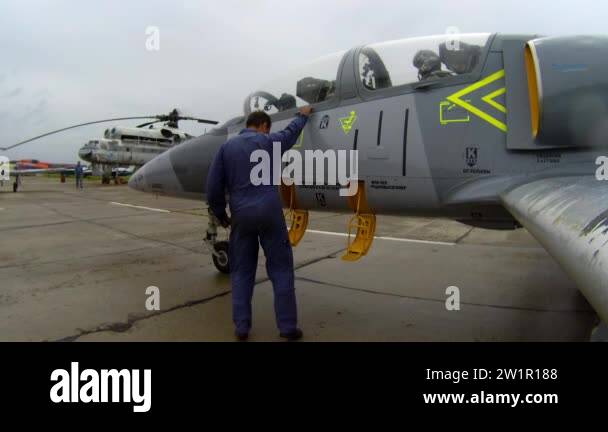 Landing Signal Officer helps the crew get out from gray aircraft ...