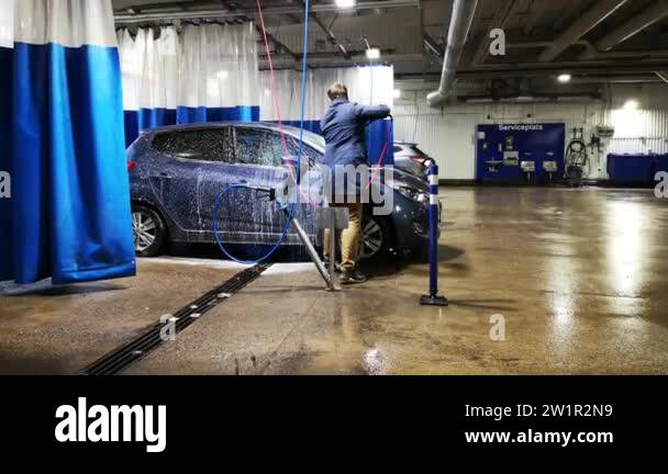 Self service car wash. Man washing his car at automobile washing ...