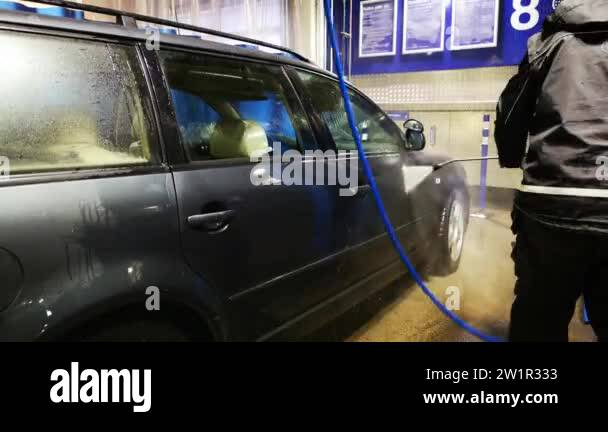Self service car wash. Man washing his car at automobile washing ...