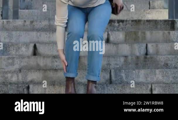 Close-up of female Caucasian legs stepping down the stairs and stopping ...