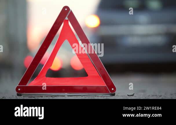 Red emergency stop sign behind broken blurred car with blinking lights ...