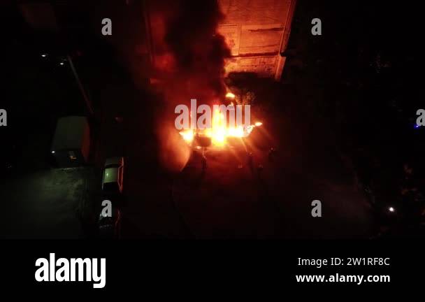 A car is burning and gasoline is dripping and burning. Unrecognizable ...