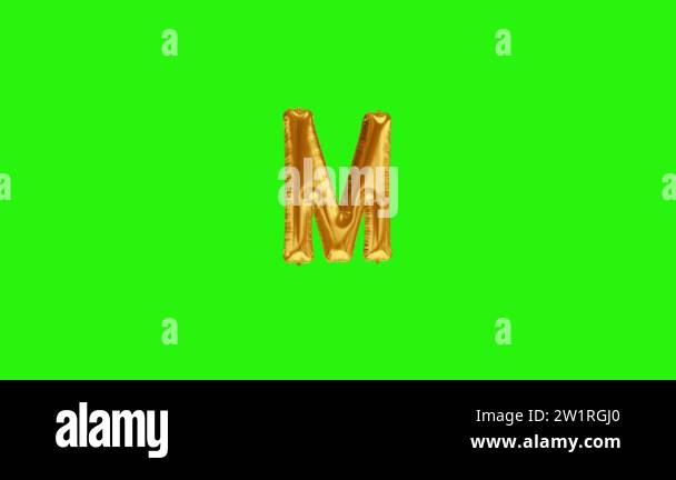 Golden letter M. Gold foil helium balloon alphabet floating on green ...