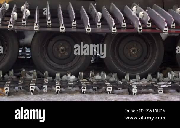 Caterpillar spikes on snowmobile in ski resort. Machine wheels with ...