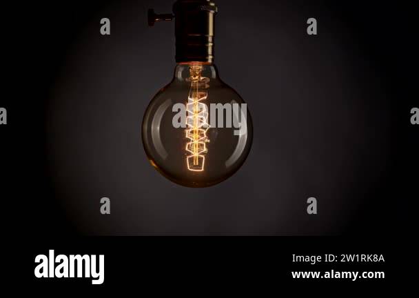 Power outage in dark room. Blinking Edison lamp swinging on wire. Black ...