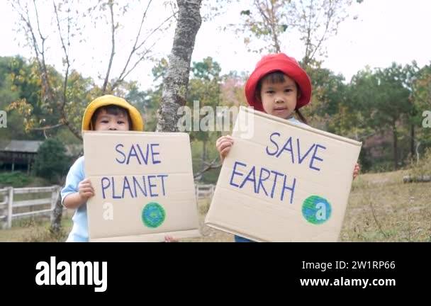 Two little child girl siblings holding "Save the planet" Poster showing ...