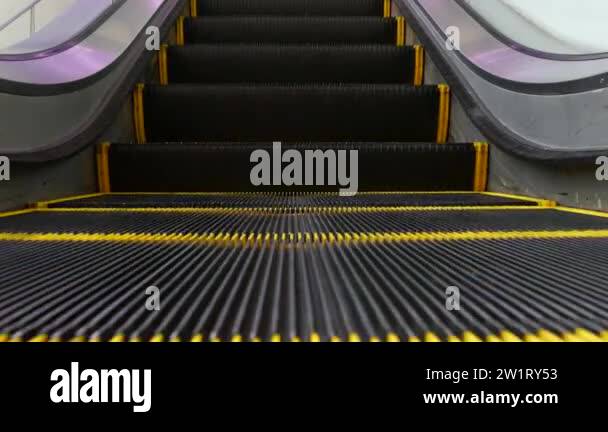 Low angle looped perspective view of modern escalator stairs. Automated ...