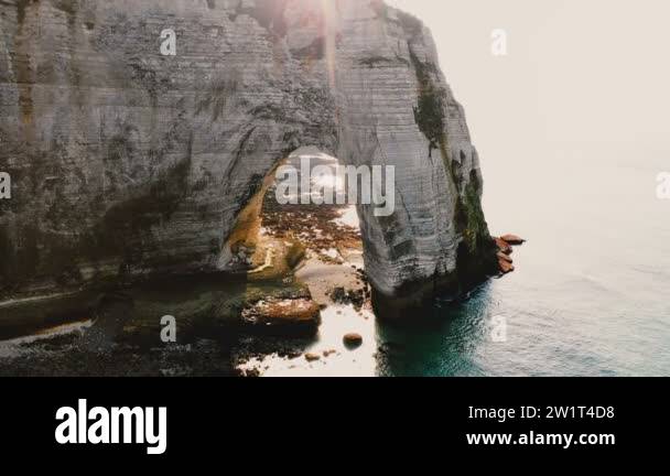 drone flying through epic natural rocky arch at famous white chalk ...