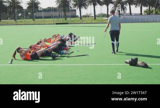 Rear view of a Caucasian male hockey coach walking and watching a team ...