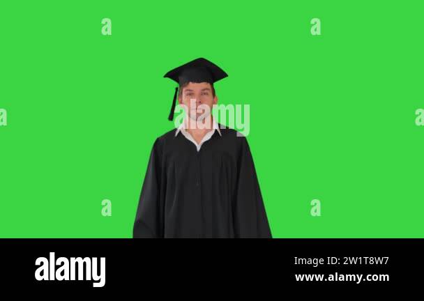 Smiling male graduate throwing his graduation hat in the air and ...