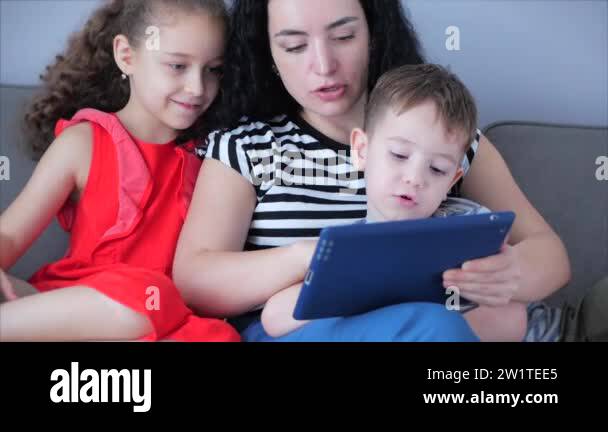 Happy family,mom and cute little children watch the phone,mom plays ...