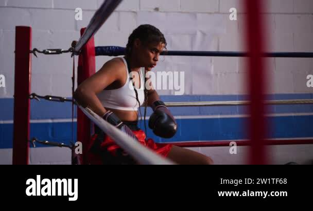 Side view of a mixed race female boxer with long plaited hair at a ...