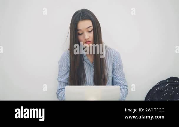 Lovely young asian lady sitting, with laptop, raising a sheet of paper ...