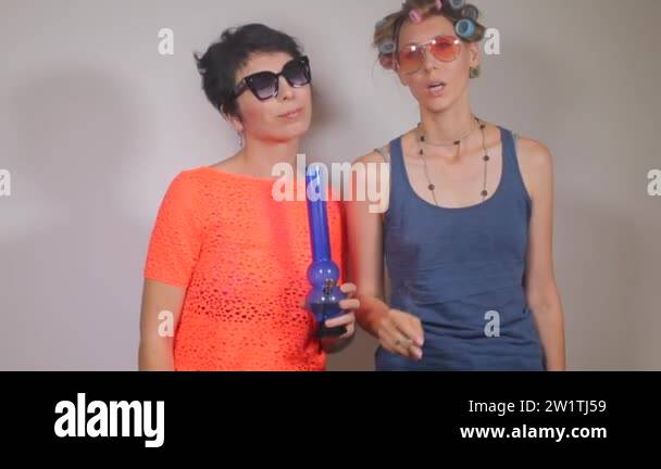 two beautiful girls smoke marijuana, one smokes joint, the second ...