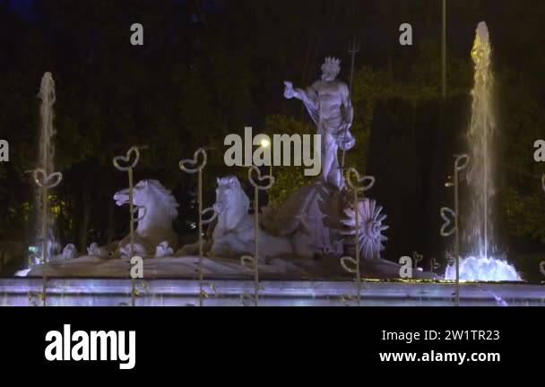 Cars moving by the statue of Fountain of Neptune (Fuente de Neptuno) at ...
