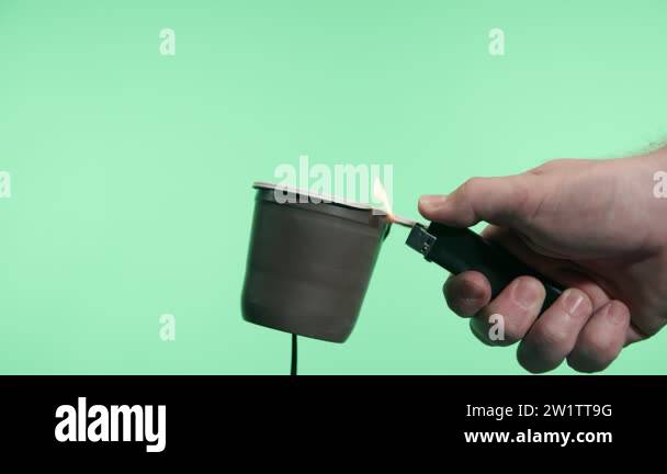 Hot flame gas lighter burns destroys disposable plastic cup on green ...
