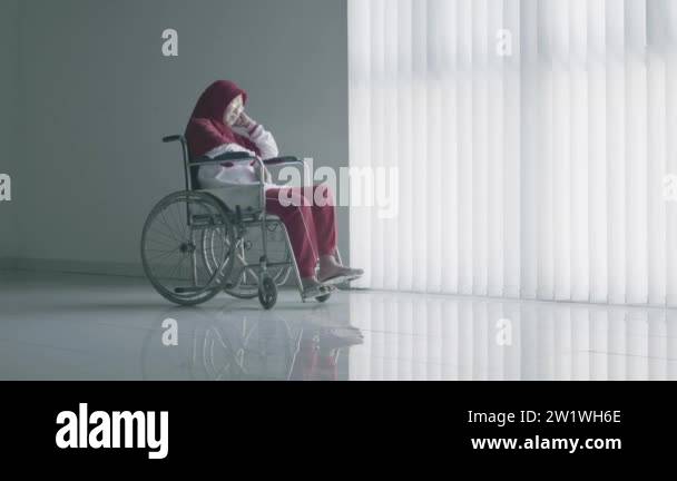 disabled fat woman sitting alone on the wheelchair near the window at ...
