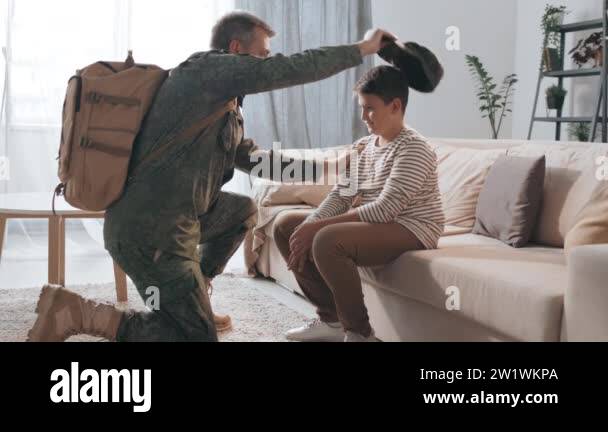 Medium shot of male army officer in military uniform kneeling before ...