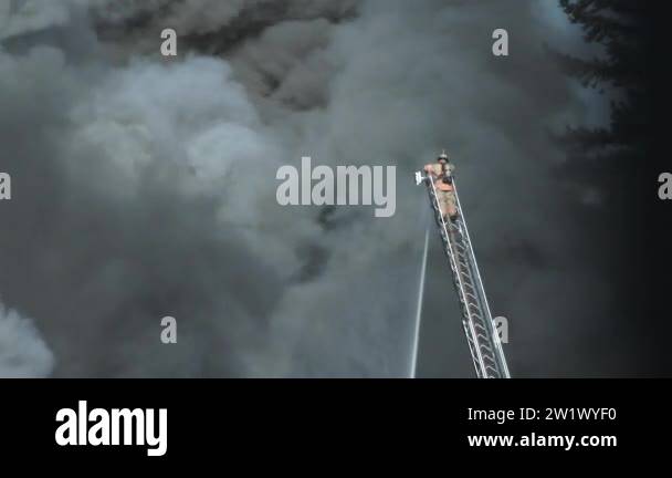 Fire fighter faces massive smoke from huge fire burning below as they ...