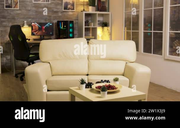 Empty room with couch in the middle and gaming computer late at night ...