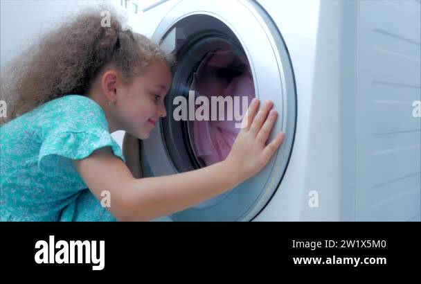 Cute Child Looks Inside the Washing Machine. Cylinder Spinning Machine ...