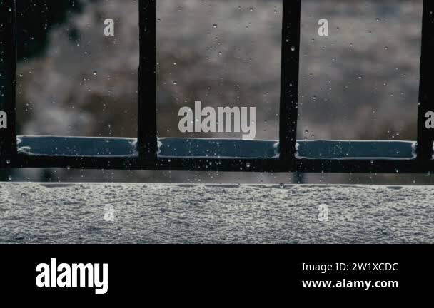 Raindrops on a window pane. Severe sea outside the window. Light wave ...