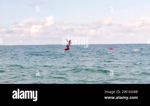 Athlete showing sport trick jumping with kite and board in air. Extreme ...