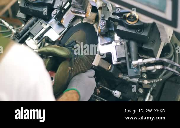 Industrial machine is being used to model a boot. Footwear factory ...
