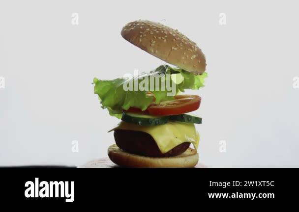 Composition of a large burger, the ingredients individually hang in the ...