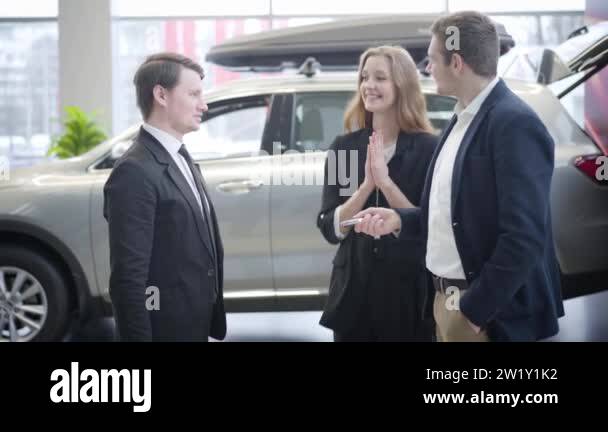 Happy young Caucasian woman jumping and clapping hands as taking car ...