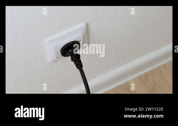 Hand Inserting black Power Plug into an white Electricity Socket. Close ...