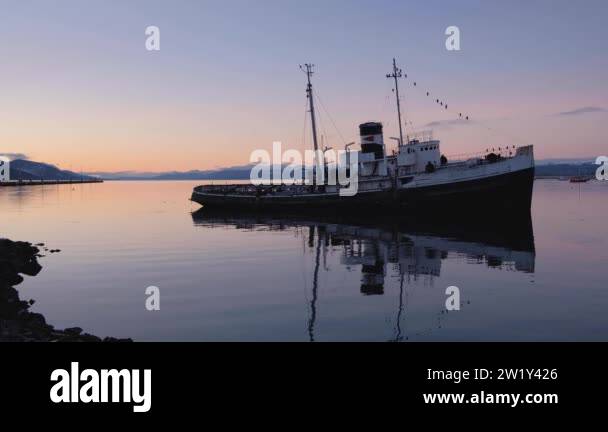 The grounded tug boat HMS Justice sits in Beagle Bay,Ushuaia at sunset ...