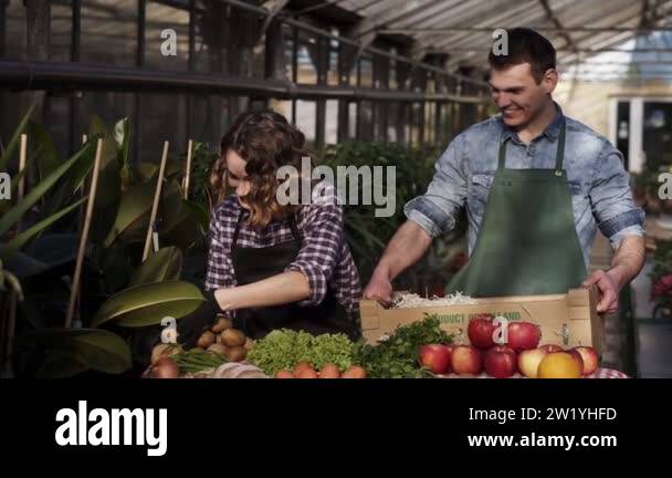 Slow motion footage of a handsome, tall man in green apron carrying the ...