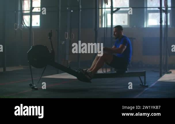 fitness man athlete training rowing machine exercise intense endurance ...