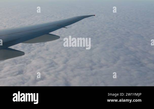 Airplane flight. Wing of an airplane flying above the clouds with ...