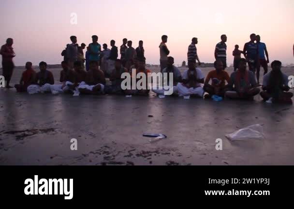 Hindu devotees praying before their holy dip during Rash Mela festival ...