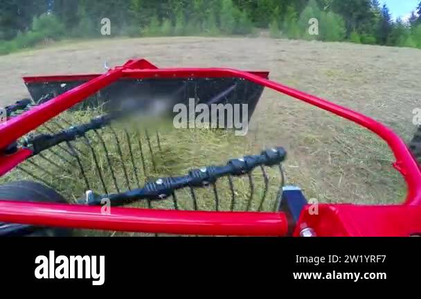 Rotary rakes are turning hay around really fast. The hay is also ...