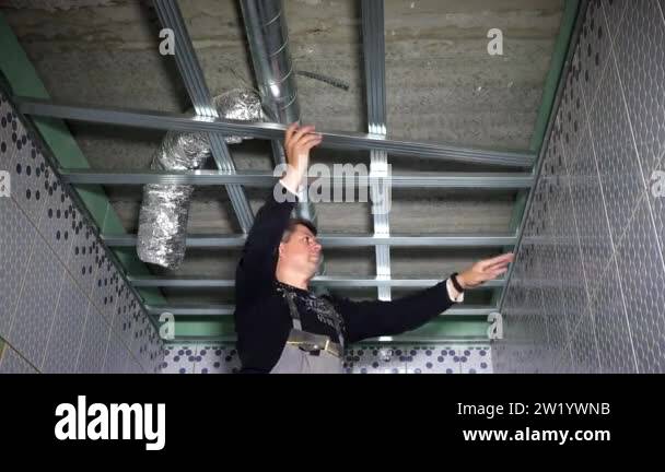 Construction master man attach aluminum ceiling profiles in new house ...