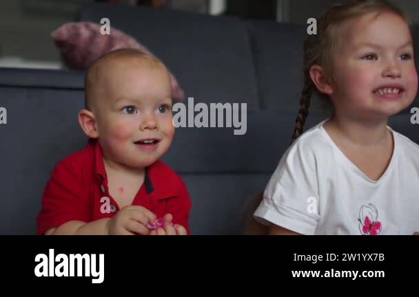 Beautiful little boy and girl clap their hands and smile. Two small ...