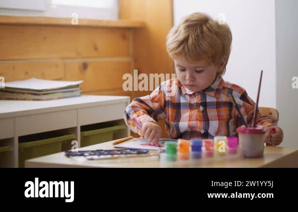 Drawing. Creativity and education concept. Happy cute boy colors his ...