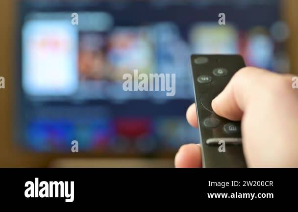 Watch TV. Closeup male hand switches television channels, on the ...