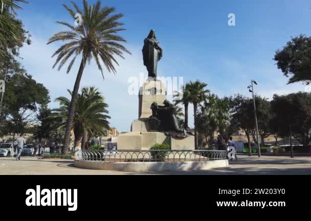 Valletta, Malta: Statue of Christ the King and tall green palm, blue ...