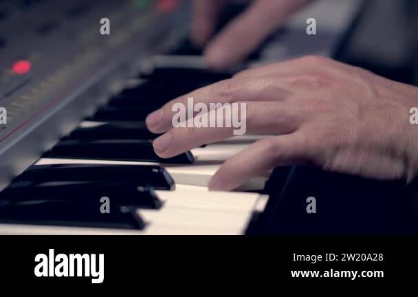 Synthesizer Keyboard. Fingers close on piano keys. Men's hands play ...
